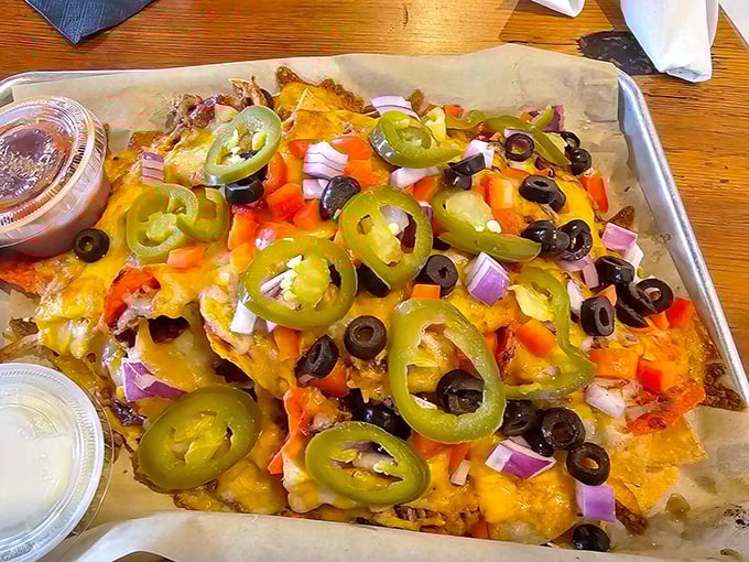 Loaded nachos that don't skimp on toppings—a mountain of jalapeños, olives, and cheese that requires a strategic eating plan.