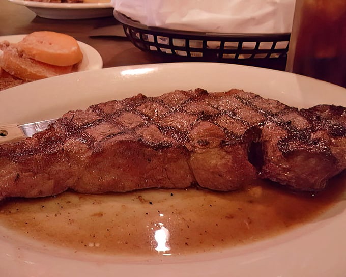 A New York Strip with the perfect crosshatch grill marks sitting in its own juices. This isn't just a steak – it's a masterclass in meat preparation.