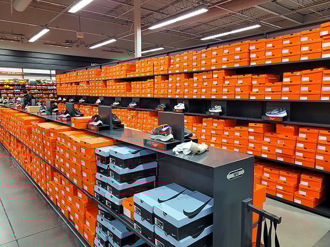 The Nike outlet's wall of orange boxes stands like the retail equivalent of the Great Pyramid—a monument to athletic aspirations and markdown magic.