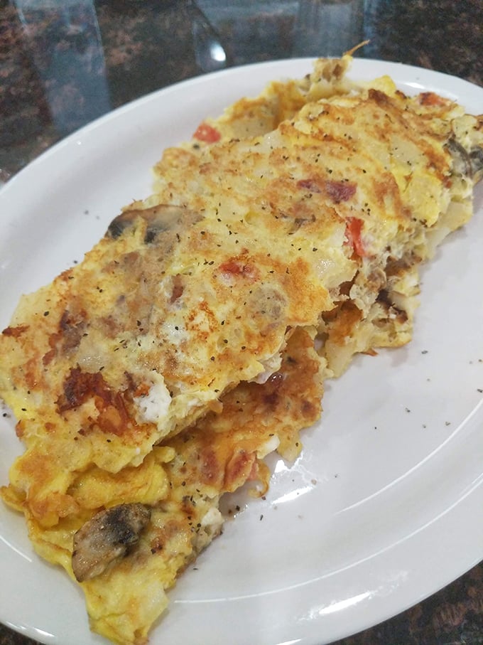 This omelet doesn't just contain mushrooms and peppers – it celebrates them in a fluffy egg embrace.