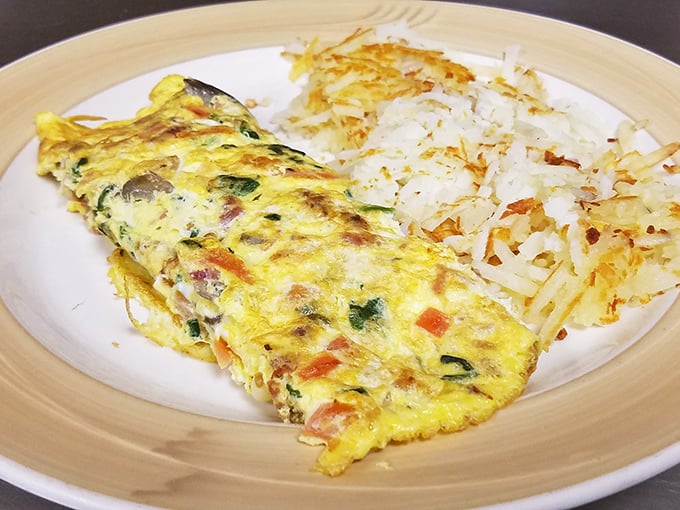 This omelet doesn't just sit on the plate – it commands respect. Perfectly executed with crispy edges and a side of hash browns that could make a potato farmer weep with pride.