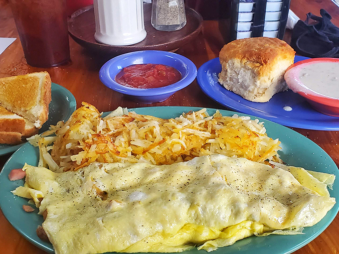 Breakfast dreams come true with this perfect omelet—fluffy, golden, and served with hashbrowns that achieve that ideal crispy-outside, tender-inside balance.