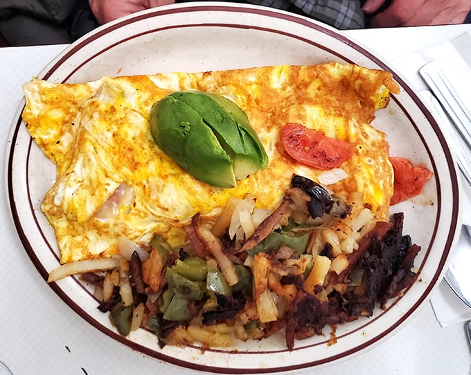 This isn't just an omelet—it's edible sunshine with avocado and home fries that could make a potato farmer weep with pride.