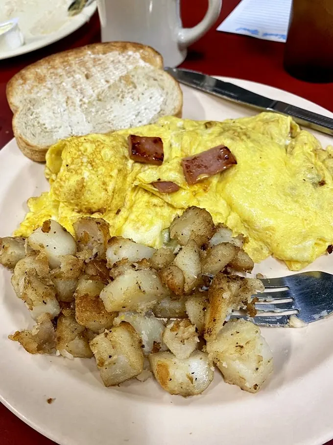 This isn't just an omelet—it's a golden canvas of perfectly cooked eggs cradling ham and potatoes with the tenderness of a lullaby.