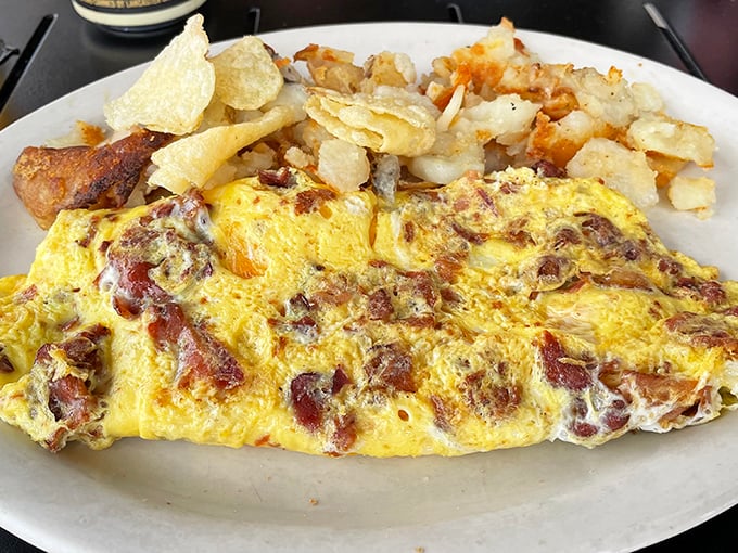 This isn't just any omelet – it's breakfast architecture, where bacon and cheese create a masterpiece that makes morning meetings worth postponing.