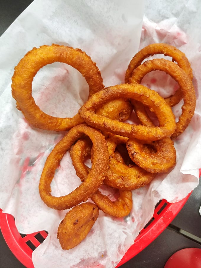 The legendary onion rings in their natural habitat—golden, crispy perfection that makes you wonder if you've been settling for mediocrity your entire life.
