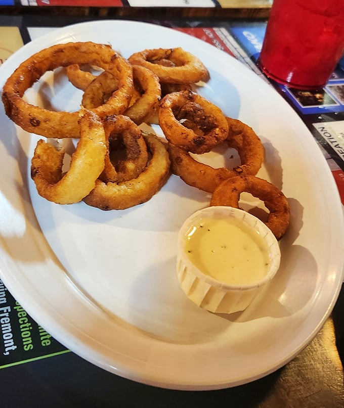 These onion rings aren't just appetizers—they're golden halos of happiness with a side of creamy dipping sauce for your dunking pleasure.