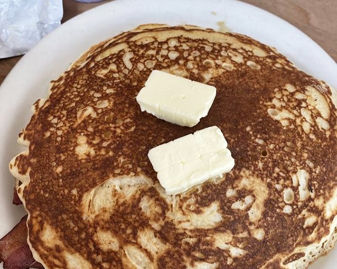 This pancake isn't just breakfast, it's architecture – a golden-brown foundation topped with butter that's melting into warm, fluffy perfection.
