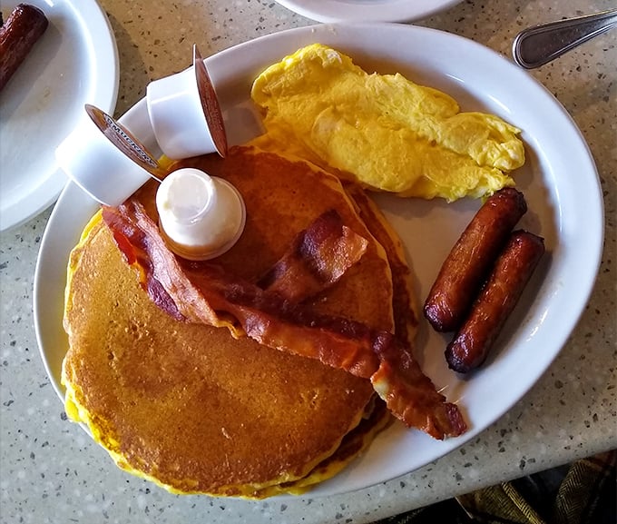 Pancakes, bacon, and eggs – the holy trinity of breakfast foods arranged on a plate like old friends at a reunion.