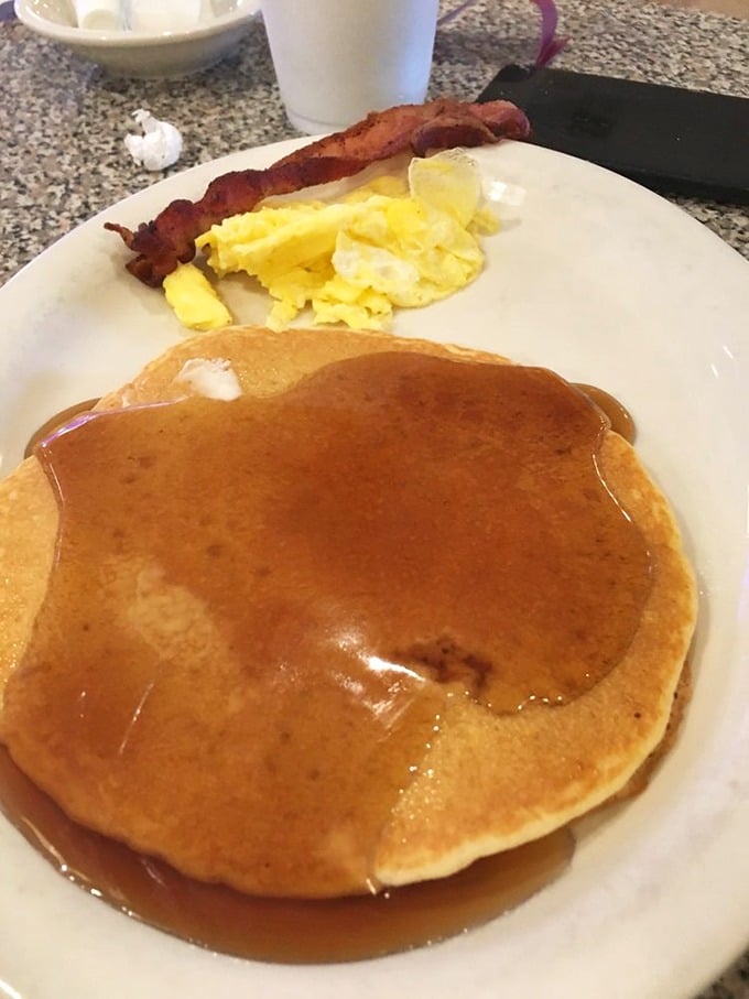 Pancakes so perfectly golden they could win medals, swimming in syrup with eggs and bacon playing supporting roles.