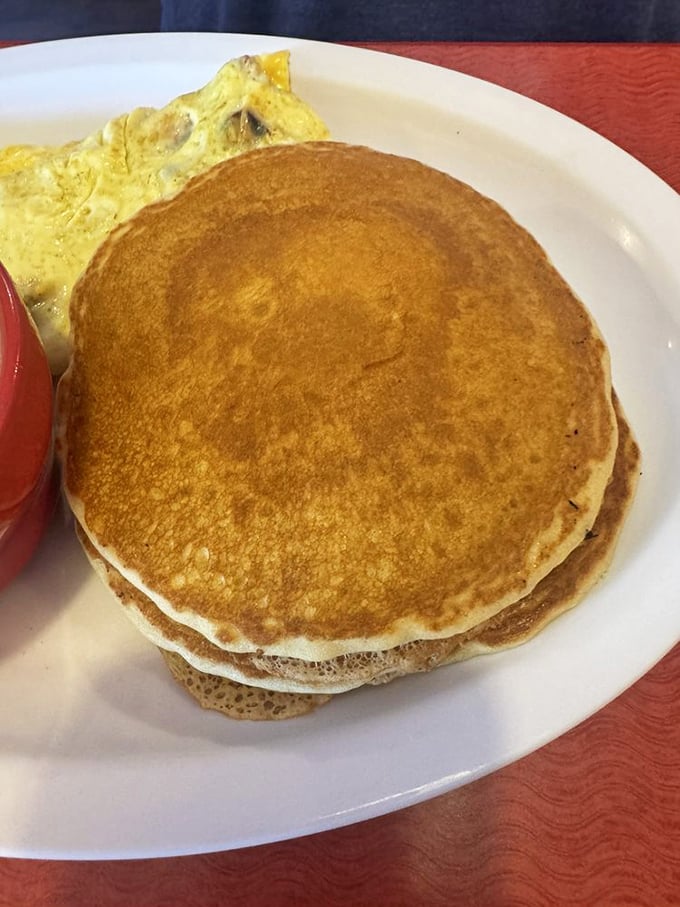 Pancakes stacked higher than your weekend plans, golden-brown and waiting for that maple syrup waterfall moment.