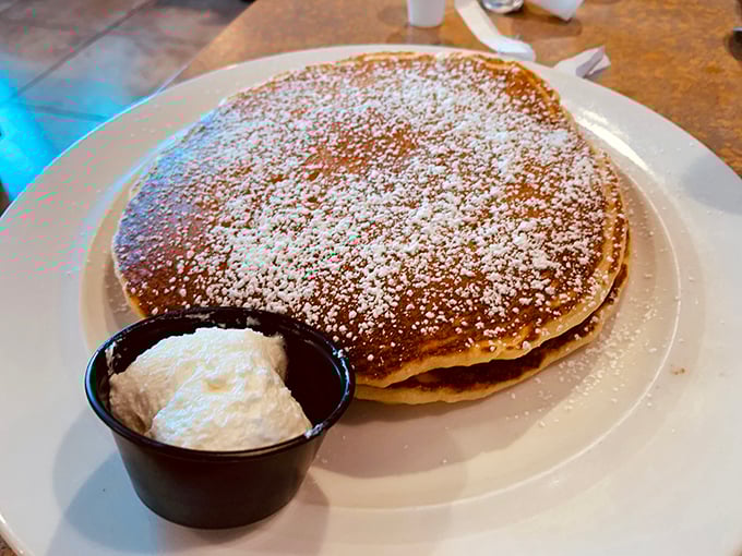 Pancakes dusted with powdered sugar and served with a side of whipped cream – breakfast's way of saying "you deserve this."