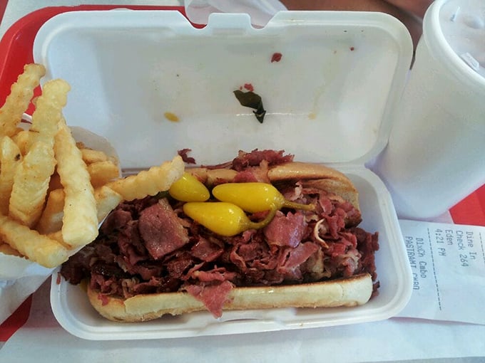 The pastrami sandwich arrives like a meaty mountain range, with mustard peaks and a generous terrain of thinly-sliced beef that would make any deli proud.