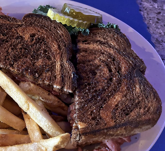 The patty melt—that perfect marriage of toasted rye, melted cheese, and beef—served with fries that look like they're auditioning for a food commercial.