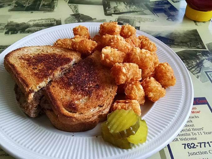 The patty melt – that perfect marriage of beef, bread, and cheese – served with tater tots that crunch like childhood memories. Simple perfection on a plate.