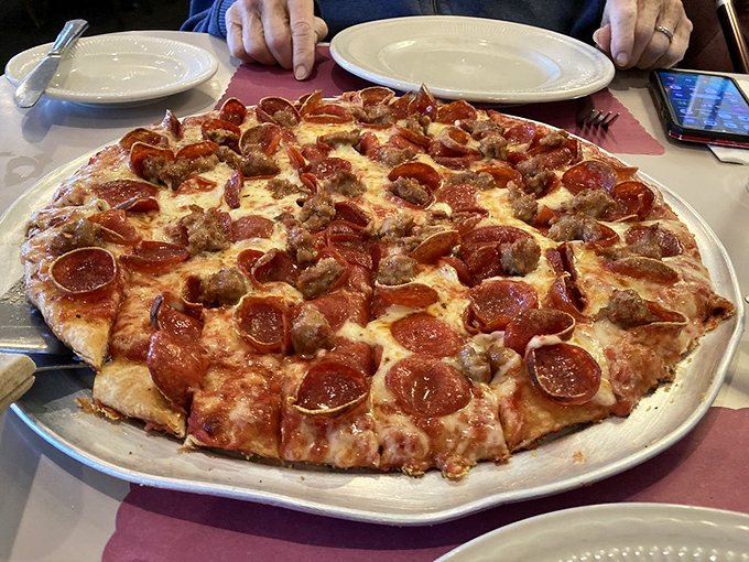 Pizza perfection doesn't need fancy toppings – just perfectly balanced pepperoni, sausage, and cheese on a crust that's been refined over decades.