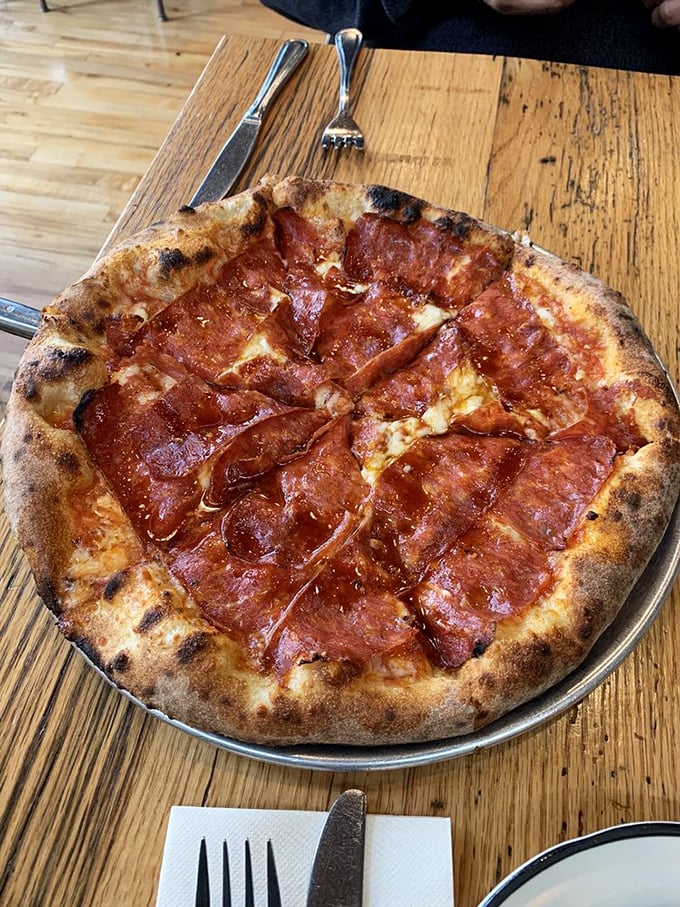 The Piccante pizza's perfect char marks tell you everything: this dough has been transformed by fire into something transcendent—a crispy, chewy miracle.