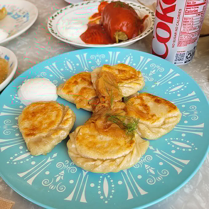 Golden-brown pierogi lounging on a turquoise plate—each one a perfect pocket of potato pleasure waiting to change your life.