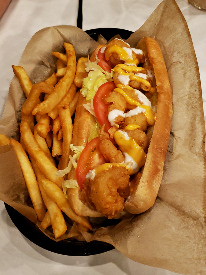 This po'boy sandwich towers like a delicious skyscraper, proving that sometimes architectural marvels come with fries.
