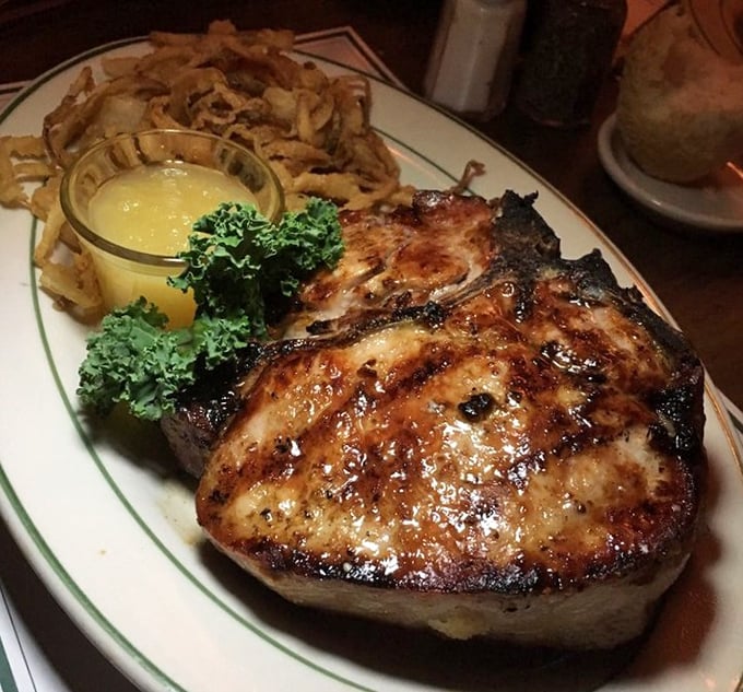 The pork chop arrives like a heavyweight champion – substantial, commanding respect, and paired with onion rings that could make you forget potatoes exist.