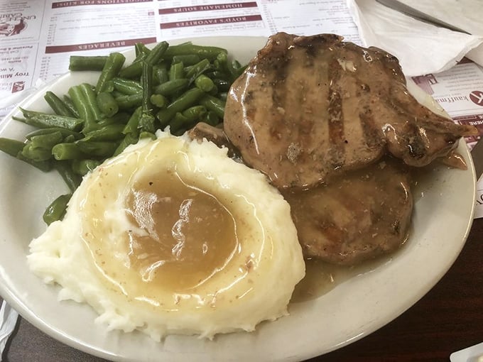 This isn't just dinner; it's edible nostalgia. The pork chop, mashed potatoes, and green beans form the holy trinity of heartland cuisine.