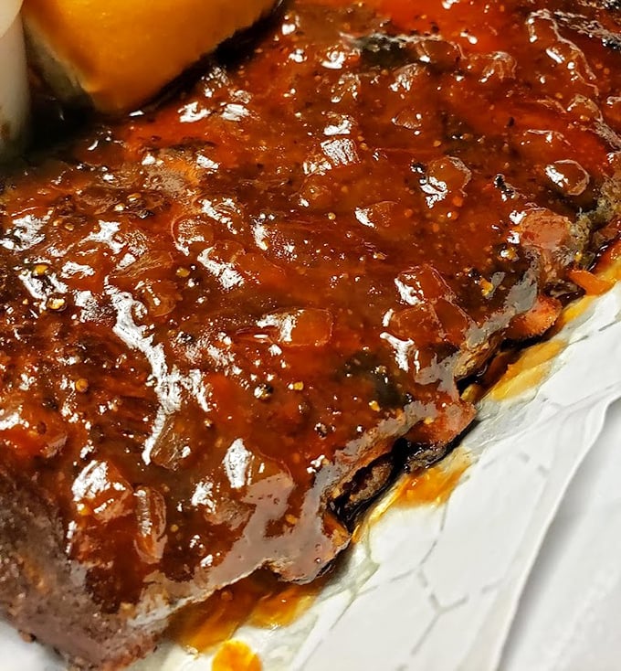 These ribs aren't just falling off the bone – they're practically jumping into your mouth, glistening with that signature sauce that balances sweet and tangy.