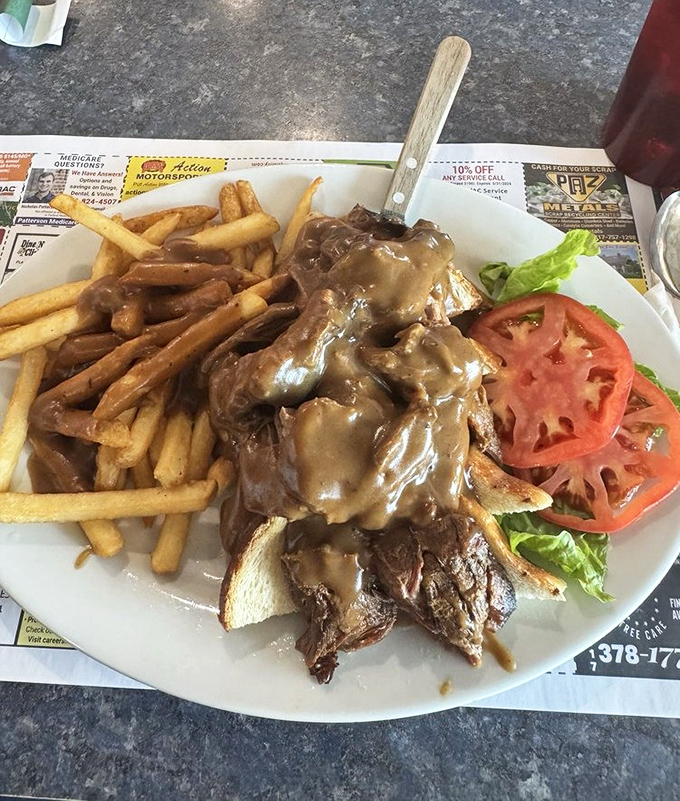 The hot roast beef sandwich—where gravy isn't just a condiment, it's a commitment. Those fries aren't just soaking it up, they're celebrating in it.