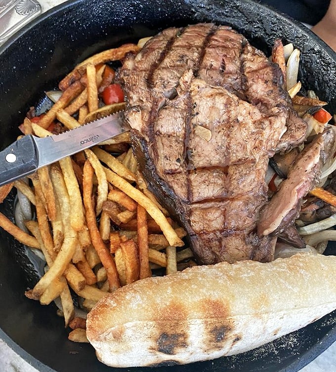 The prime rib arrives like a carnivore's dream – seared to perfection, nestled alongside golden fries and a baguette ready to soak up those precious juices.