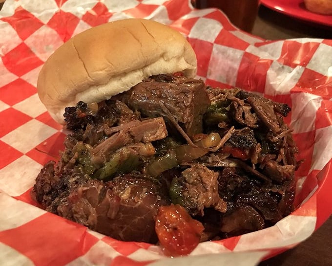 The pulled beef sandwich arrives like a mountain of bark-studded treasure, with green peppers adding both color and a perfect counterpoint to the rich meat.