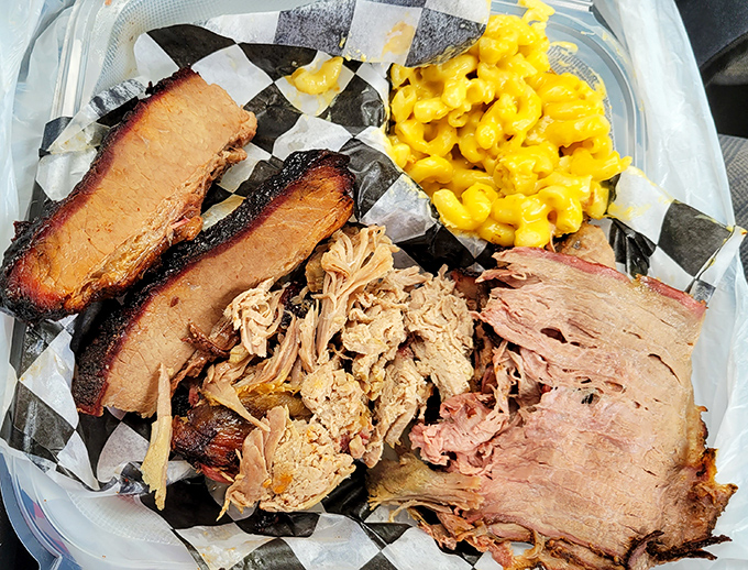 Meat candy in its purest form—brisket with that telltale smoke ring, pulled pork with perfect texture, and mac and cheese playing the perfect supporting role.