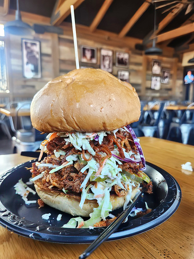 This pulled pork sandwich isn't just a meal, it's an architectural marvel – a delicious Jenga tower of meat, slaw, and bun that dares you to find a dignified way to eat it.