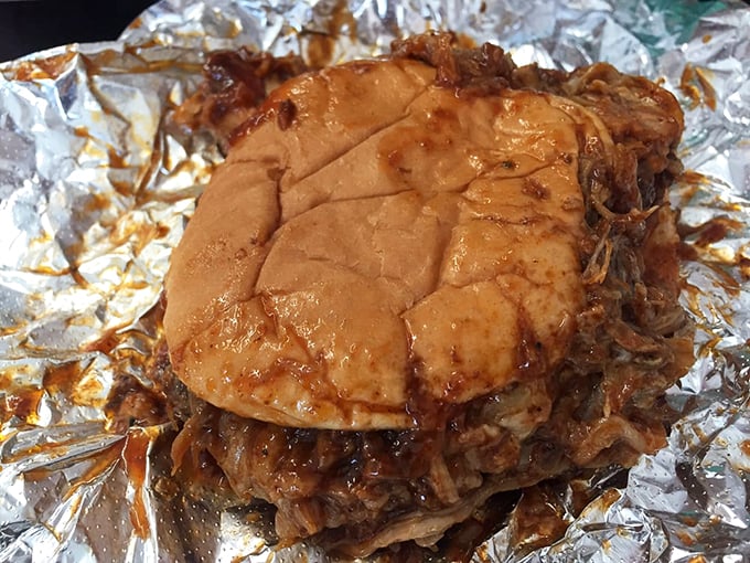 The pulled pork sandwich doesn't need fancy presentation—just a humble bun struggling heroically to contain a mountain of smoky, saucy perfection.