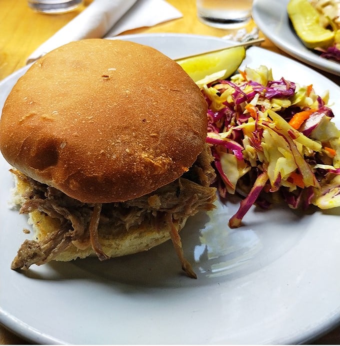 This pulled pork sandwich isn't just a meal, it's an event – tender meat on a fresh-baked bun with house-made slaw that adds crunch and color.