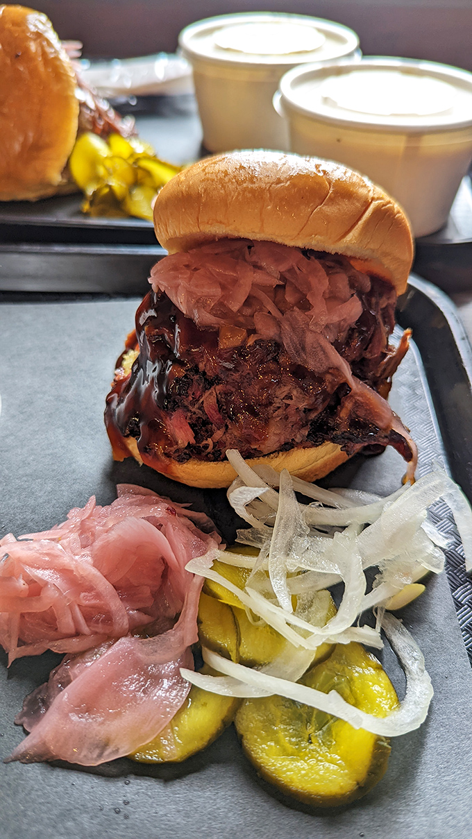 This isn't just a sandwich—it's an architectural marvel of smoke-kissed pulled pork that requires both hands and possibly a bib.