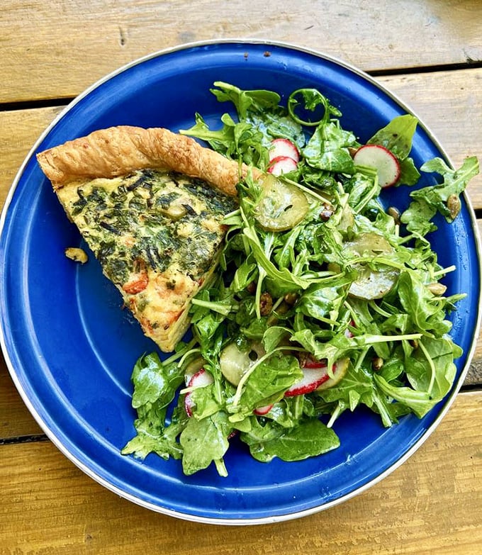 A slice of savory quiche with a side salad—proof that "eating your vegetables" can be the highlight of your day rather than a chore.