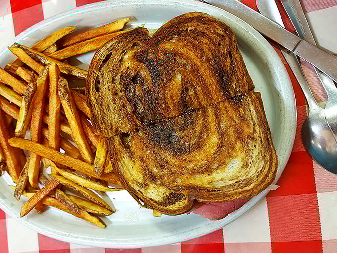 This isn't just a grilled sandwich – it's a masterclass in texture, with golden-brown bread giving way to melty goodness alongside crispy fries.