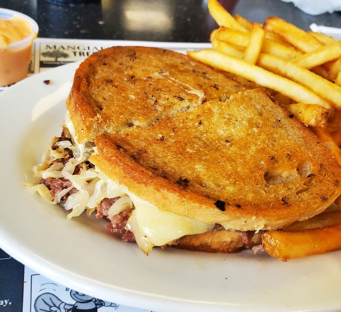 This isn't just a sandwich; it's architecture. Perfectly grilled bread supporting the delicate balance of sauerkraut, meat, and melted cheese—with fries standing guard.