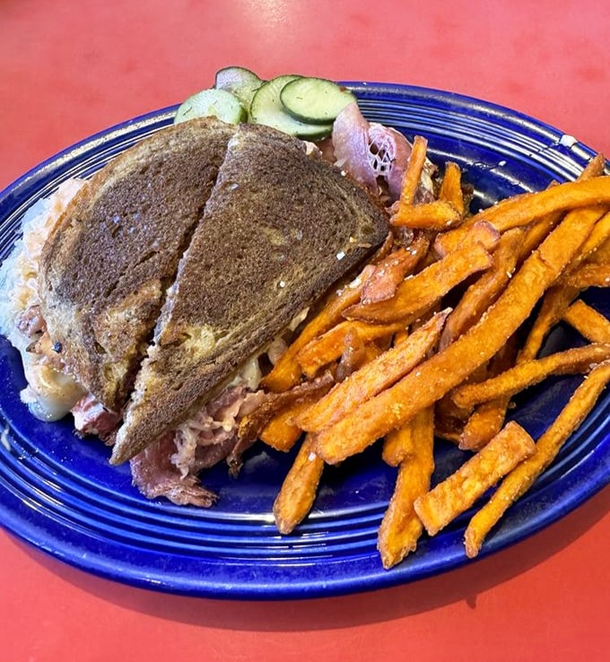 The Reuben arrives like a sandwich superhero – cape optional, sweet potato fries mandatory, satisfaction guaranteed.