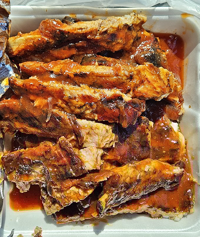 These ribs aren't just falling off the bone—they're practically volunteering to jump onto your plate, swimming in a sauce worth bottling and hoarding.