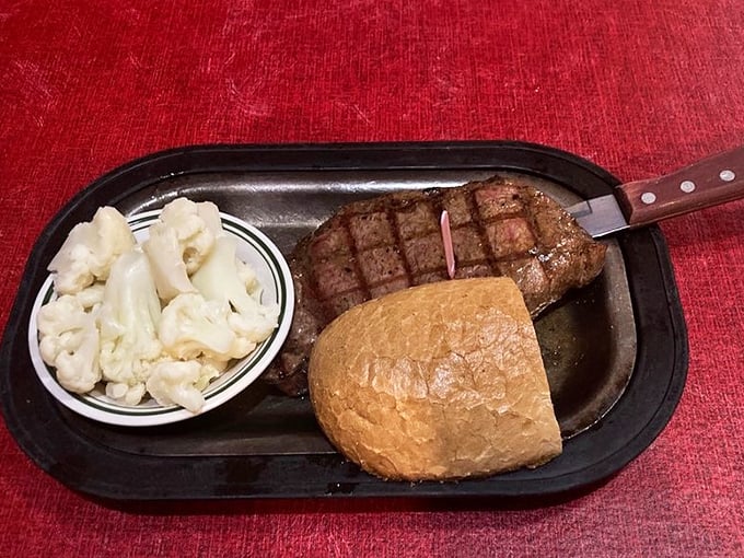 A perfectly grilled ribeye with cauliflower and roll – proof that happiness doesn't need to be complicated, just expertly prepared and served hot.