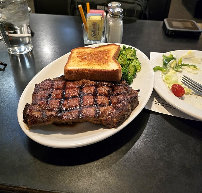 This ribeye isn't just grilled—it's been coaxed to perfection, sporting grill marks that deserve their own Instagram account.