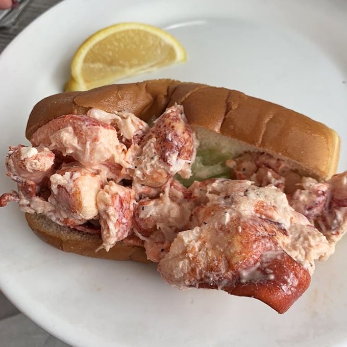 Lobster roll heaven! Chunks of sweet meat barely contained by a toasted bun—this isn't a sandwich, it's a celebration with a lemon wedge.