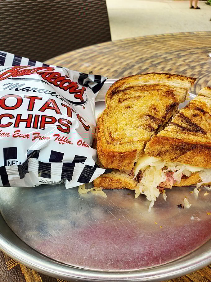 The Reuben arrives like a savory celebrity, accompanied by its faithful sidekick—a bag of Conn's potato chips from Tiffin, Ohio.