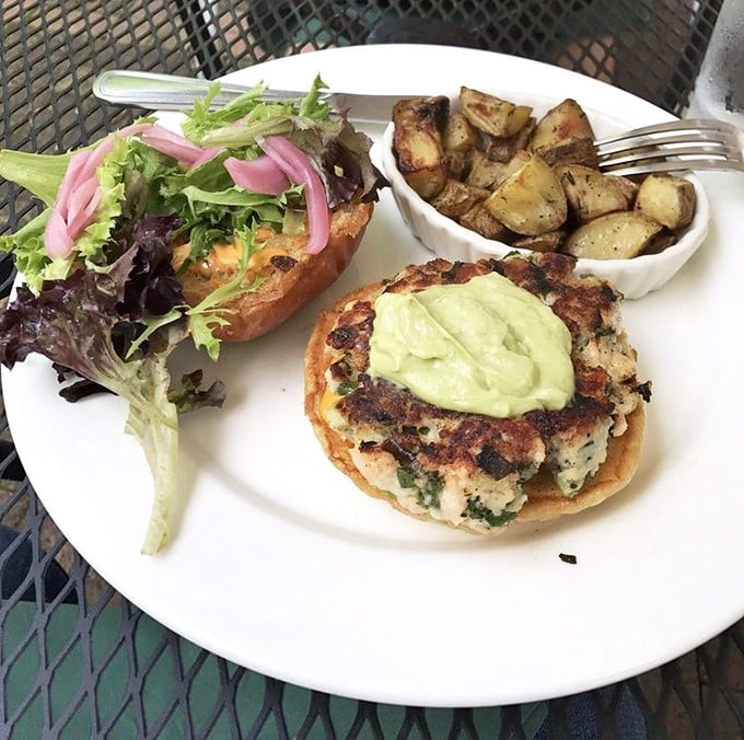 The salmon burger arrives like a work of art – crispy exterior, tender inside, topped with creamy avocado sauce that'll make you forget all other condiments exist.