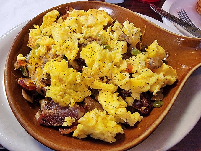 Breakfast alchemy at its finest—eggs, meat, and vegetables performing a morning symphony in a skillet that's seen more action than a Western movie.
