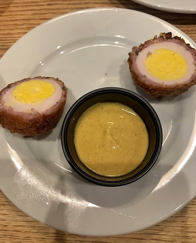 The humble Scotch egg, elevated to art form. Perfectly runny yolk encased in seasoned ground pork and a crispy exterior – Britain's greatest contribution to handheld food.