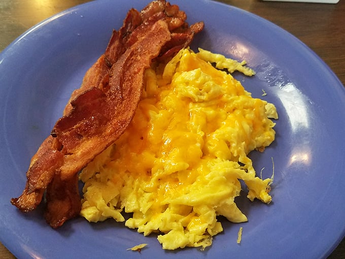 Breakfast perfection doesn't need fancy plating—just perfectly scrambled eggs alongside bacon that's achieved that magical balance between crisp and chewy.
