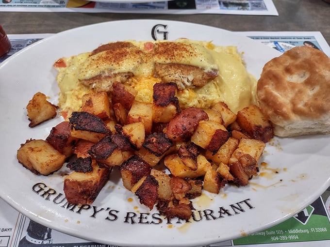 Breakfast architecture at its finest: a golden seafood omelet, crispy potatoes, and a biscuit standing guard—the holy trinity of morning satisfaction.