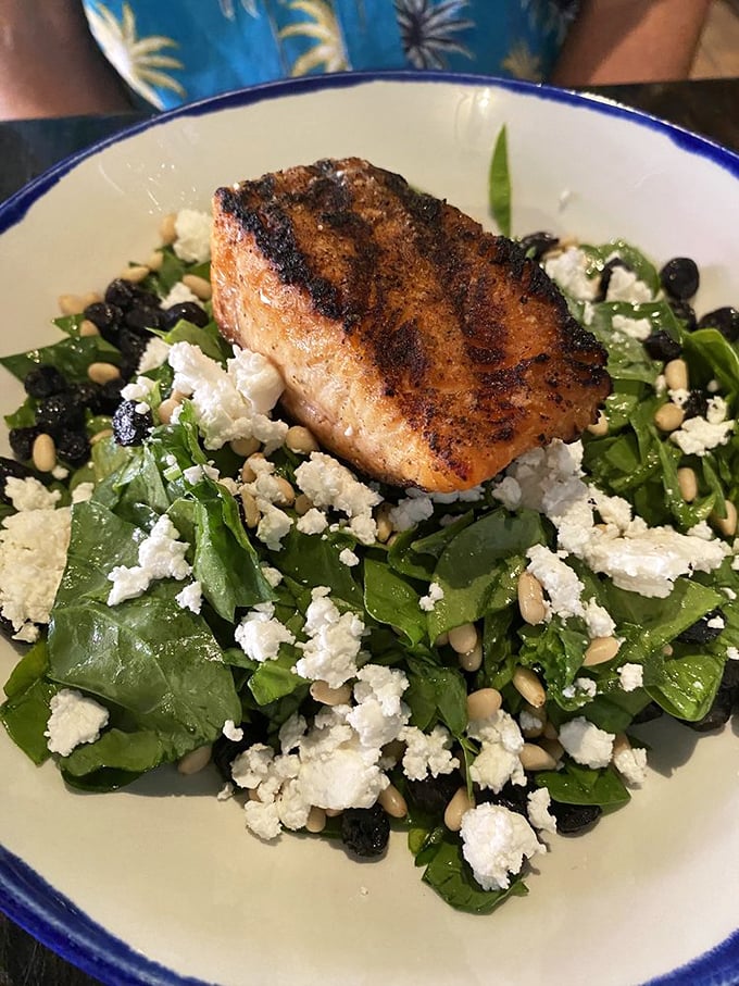 This isn't just salmon on salad – it's a perfectly seared piece of Alaska perched atop a bed of greens like it's surveying its delicious kingdom.