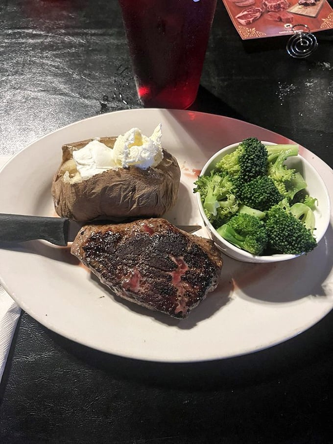 A perfectly cooked sirloin, a loaded baked potato, and broccoli that's there to make you feel virtuous while you devour that glorious meat.